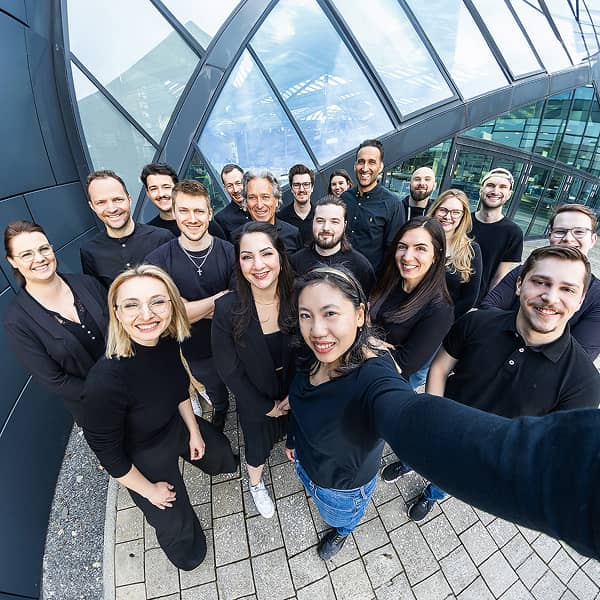 Gruppenfoto des mindtwo Teams im Freien, aufgenommen mit Fisheye-Perspektive